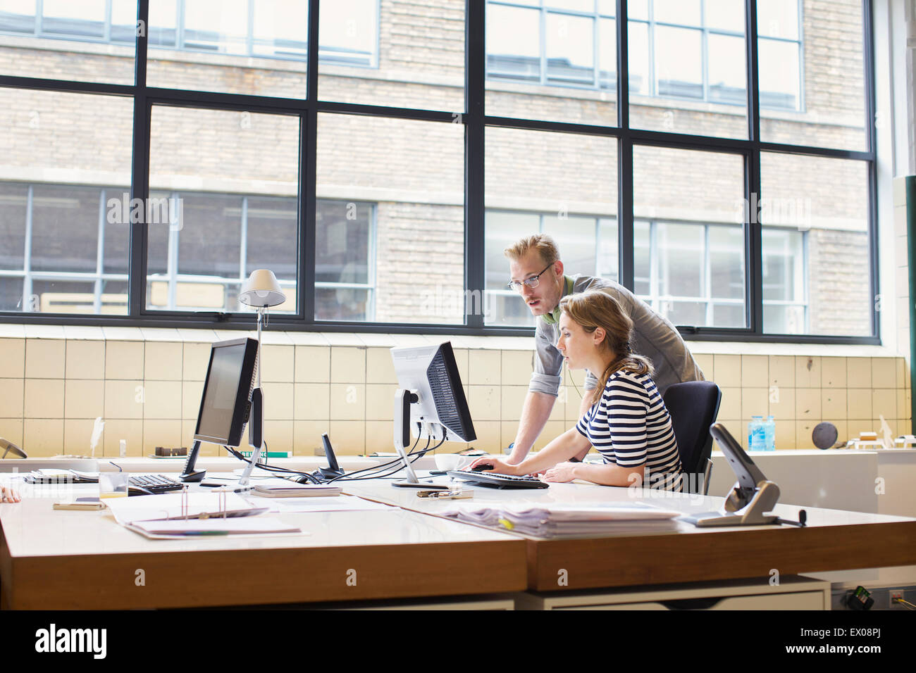 Colleagues having informal meeting at office desk Stock Photo - Alamy