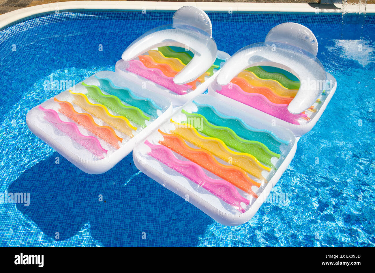 Colorful floating air mattresses in swimming pool at summertime as ...