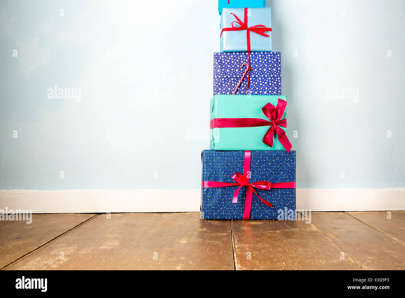 Stack of five wrapped christmas gifts on wooden floor Stock Photo - Alamy