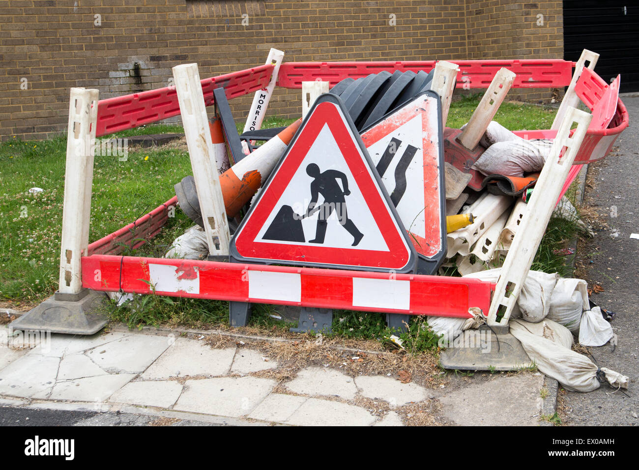 Pile of roadwork signs left alongside footpath Stock Photo - Alamy