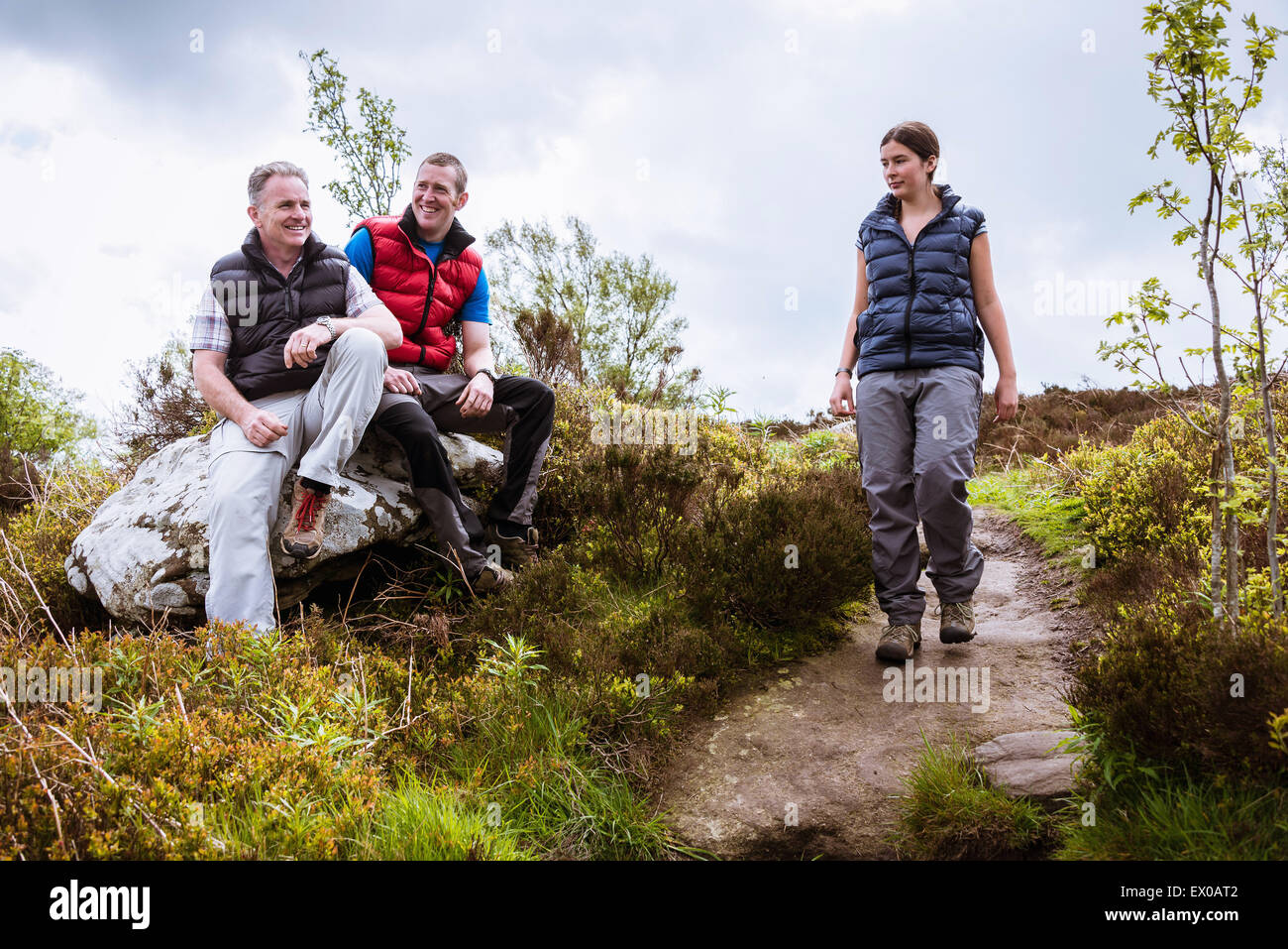 Hiking friends chatting on rock, Pateley Bridge, Nidderdale, Yorkshire ...