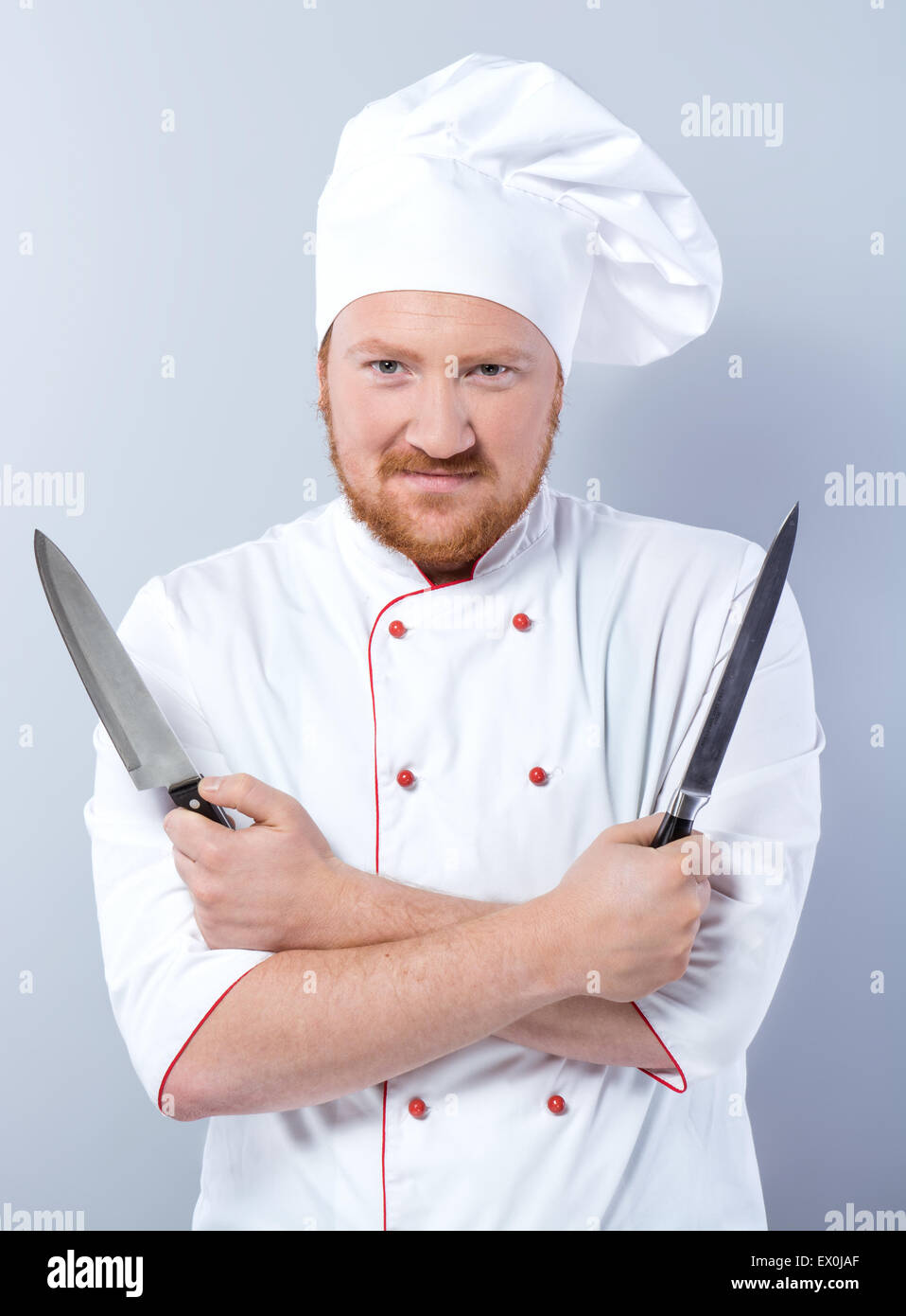 Head-cook holding two knives and looking at camera Stock Photo - Alamy