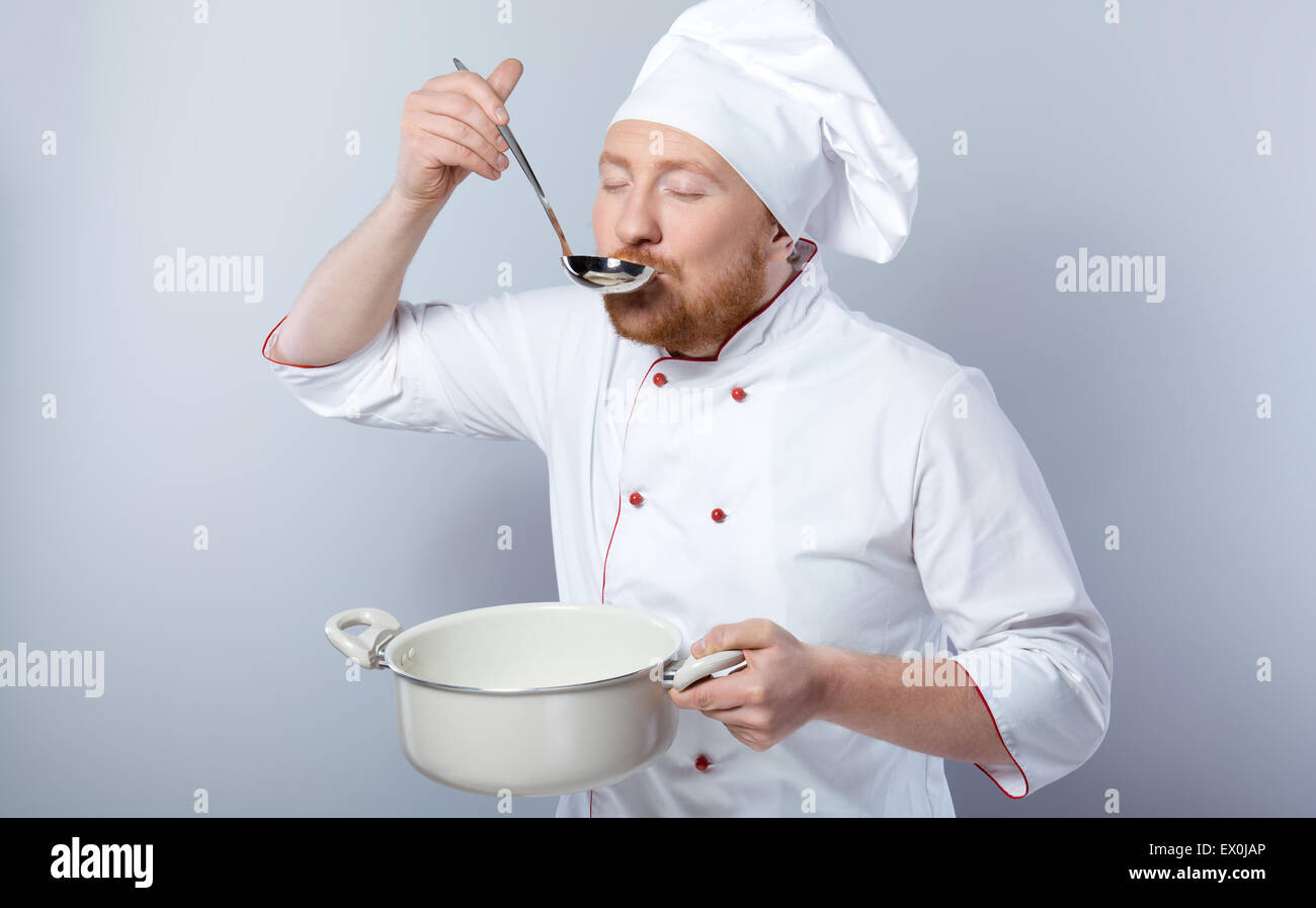 Head-cook tasting food from saucepan Stock Photo - Alamy