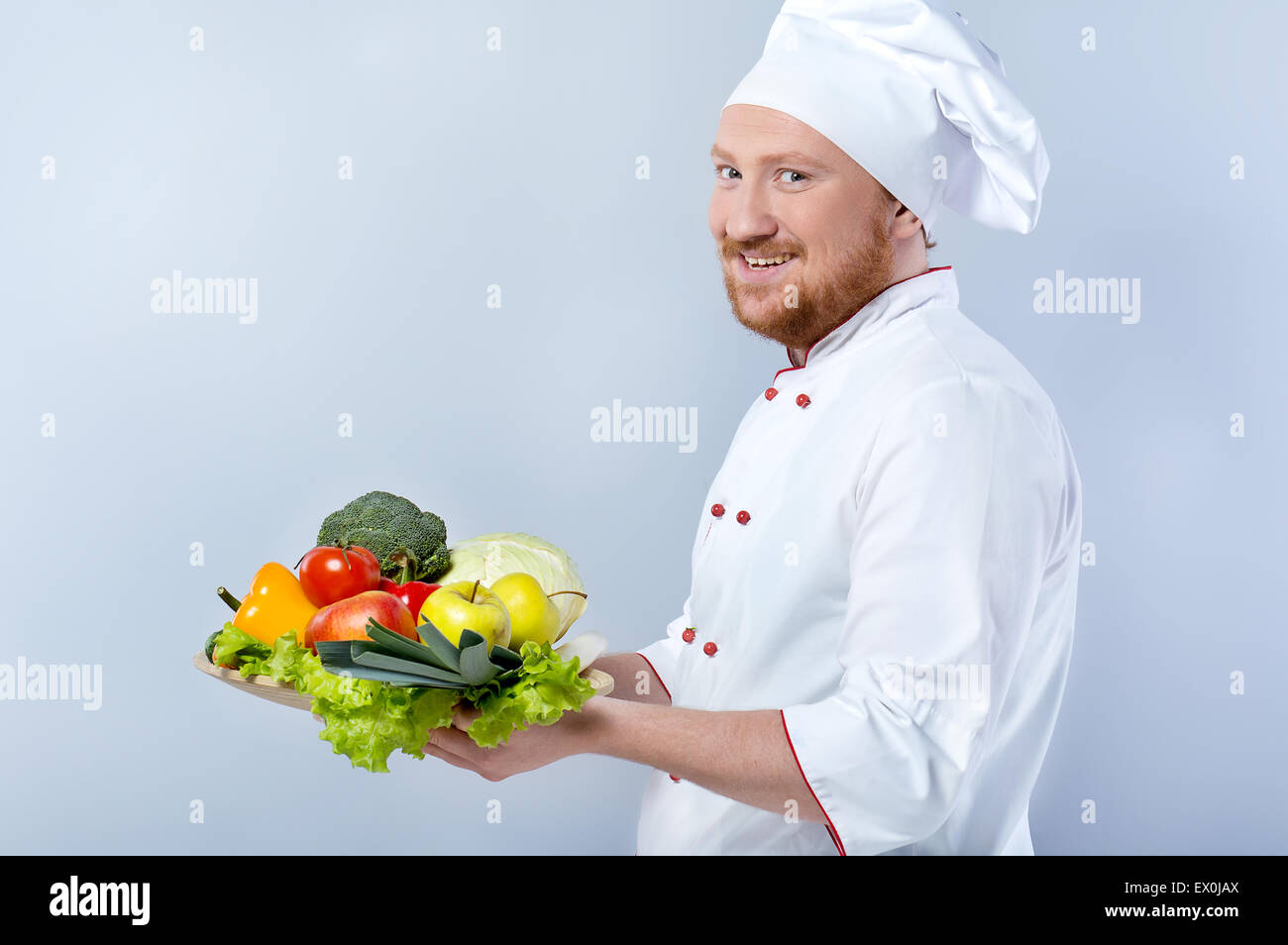 Head-cook holding big plate of fresh vegetables Stock Photo - Alamy