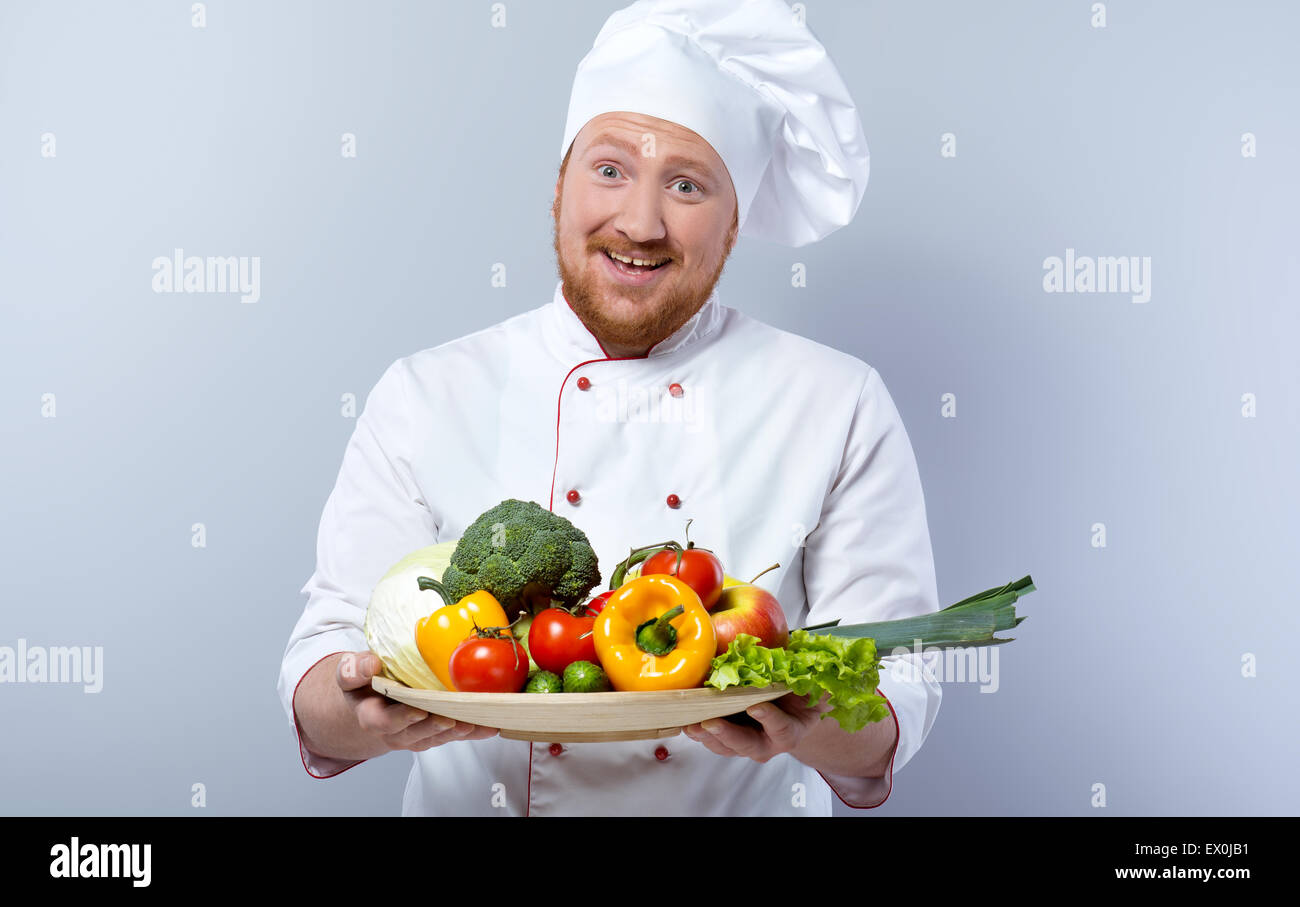 Head-cook holding big plate of fresh vegetables Stock Photo - Alamy