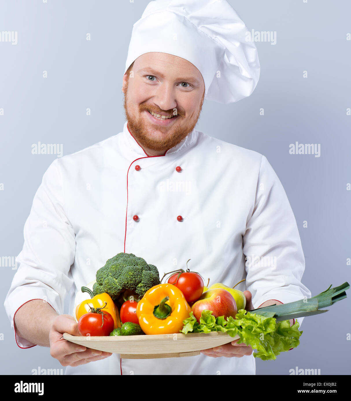Head-cook holding big plate of fresh vegetables Stock Photo - Alamy