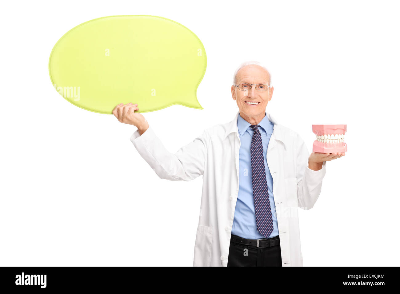 Mature dentist in white coat holding a denture and a big yellow speech ...