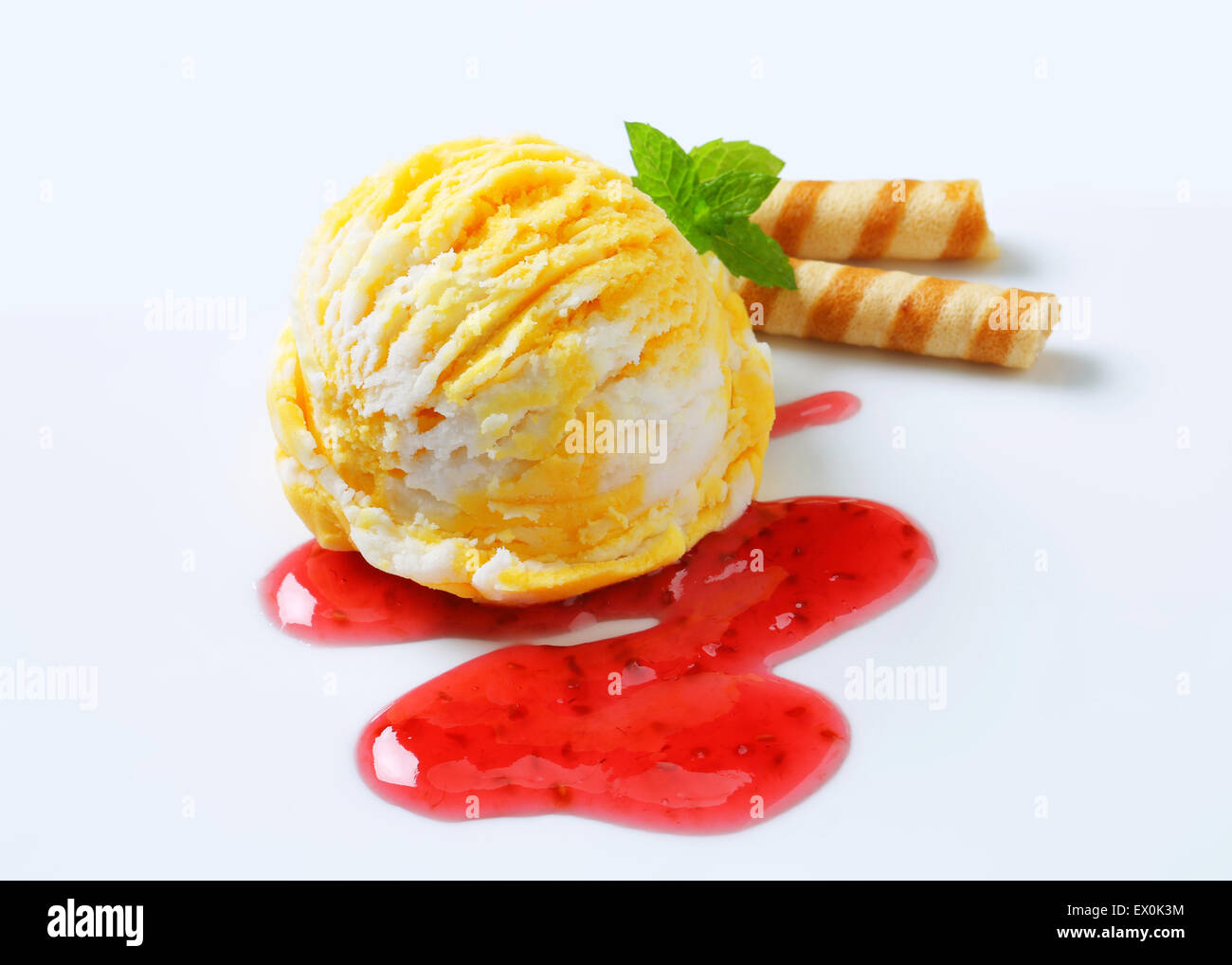 Scoop of mango lemon ice cream with raspberry sauce Stock Photo - Alamy