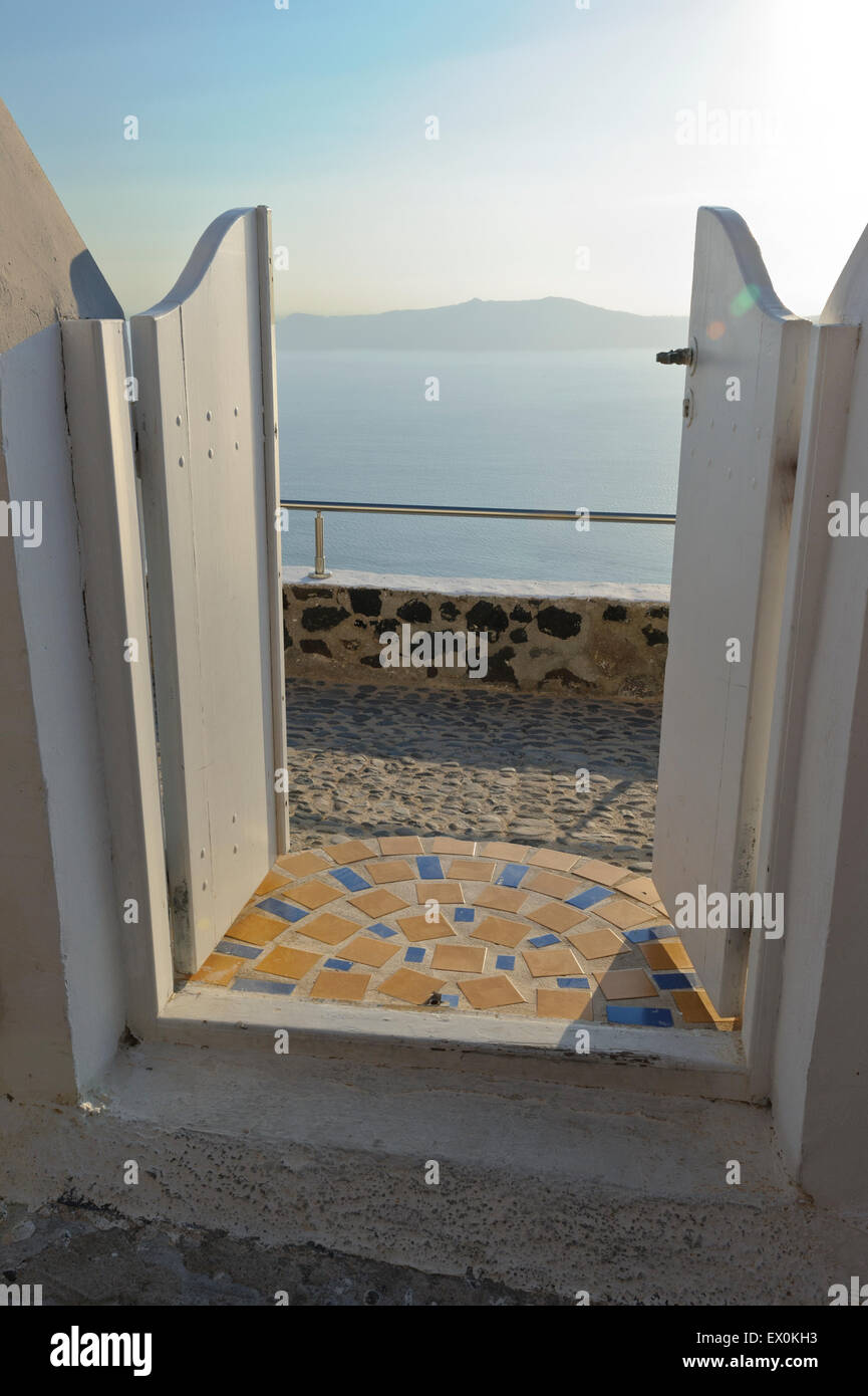 An open gate with tile flooring with a view of the sea and distant ...