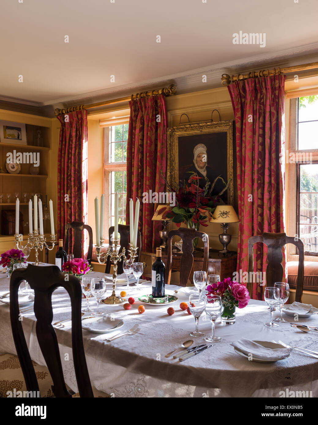 Gilt framed portait on wall of dining room with candelabra and floor ...