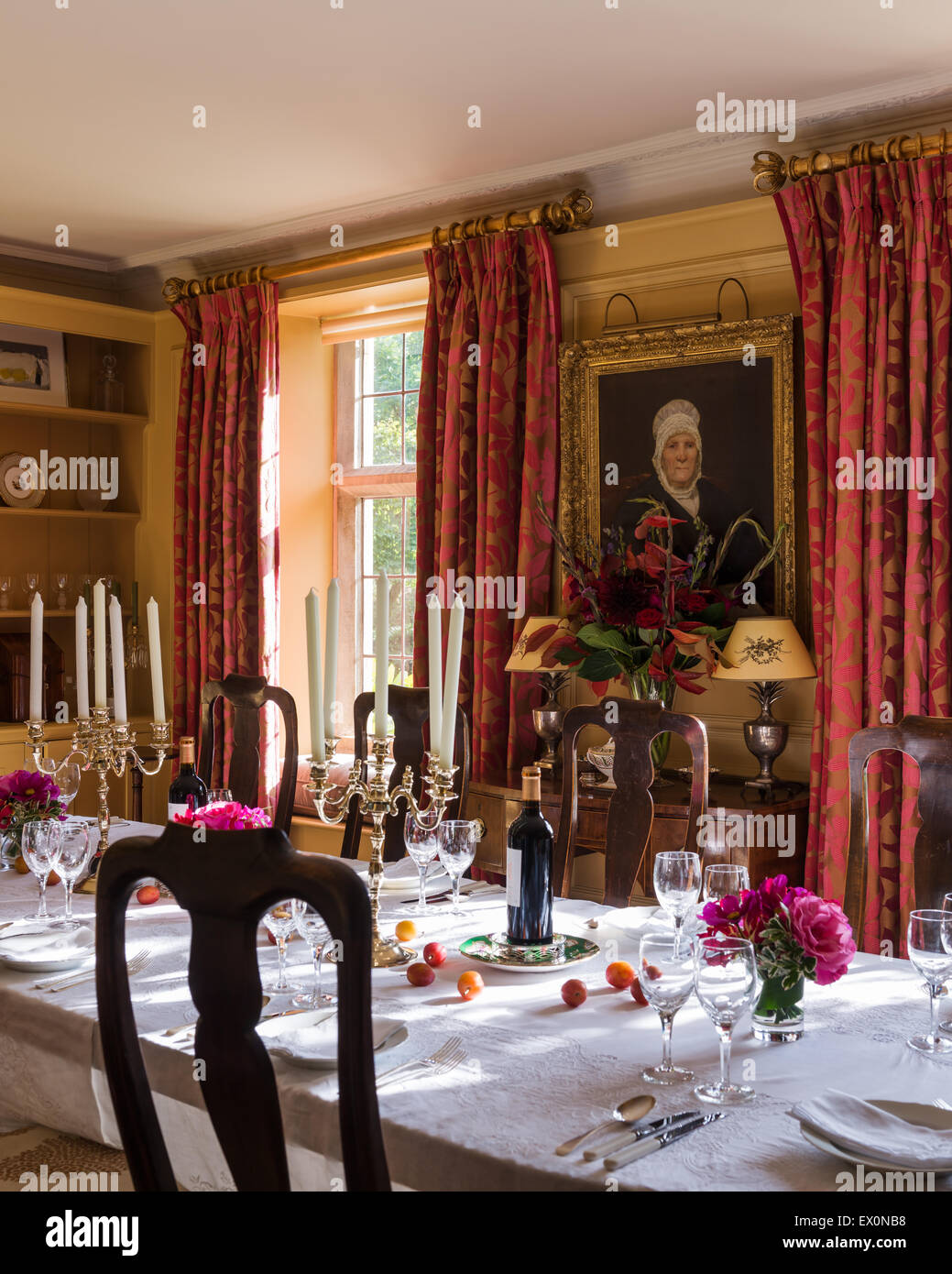 Gilt framed portait on wall of dining room with candelabra and floor ...