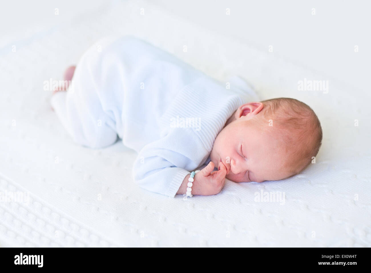 Cute newborn baby sleeping on his tummy on a white knitted blank Stock ...