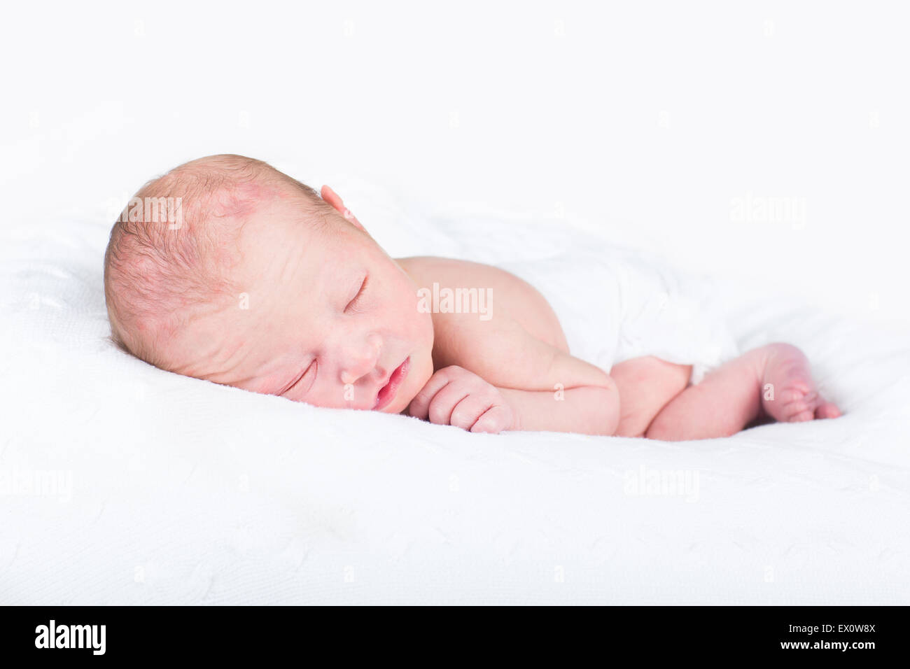 One day old newborn baby boy smiling while relaxing on his tummy Stock ...