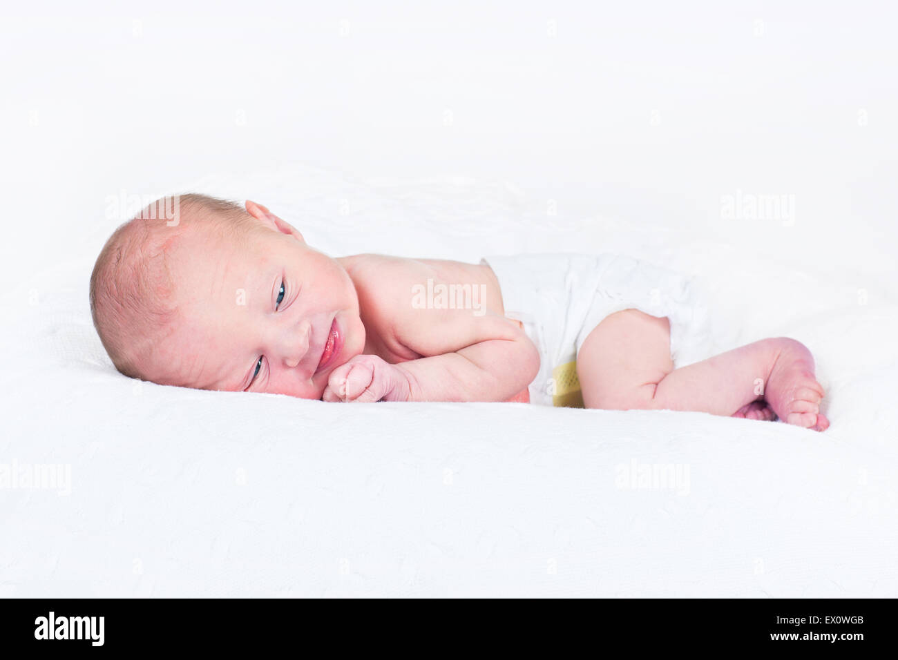 One day old newborn baby boy smiling while relaxing on his tummy Stock ...