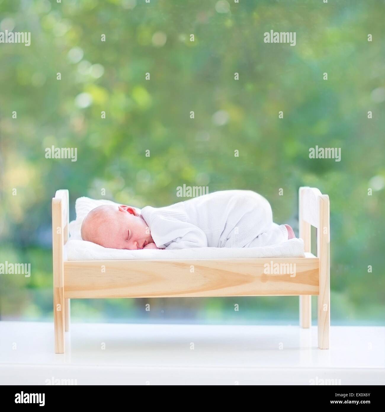 Sweet newborn baby boy in a white round crib Stock Photo - Alamy