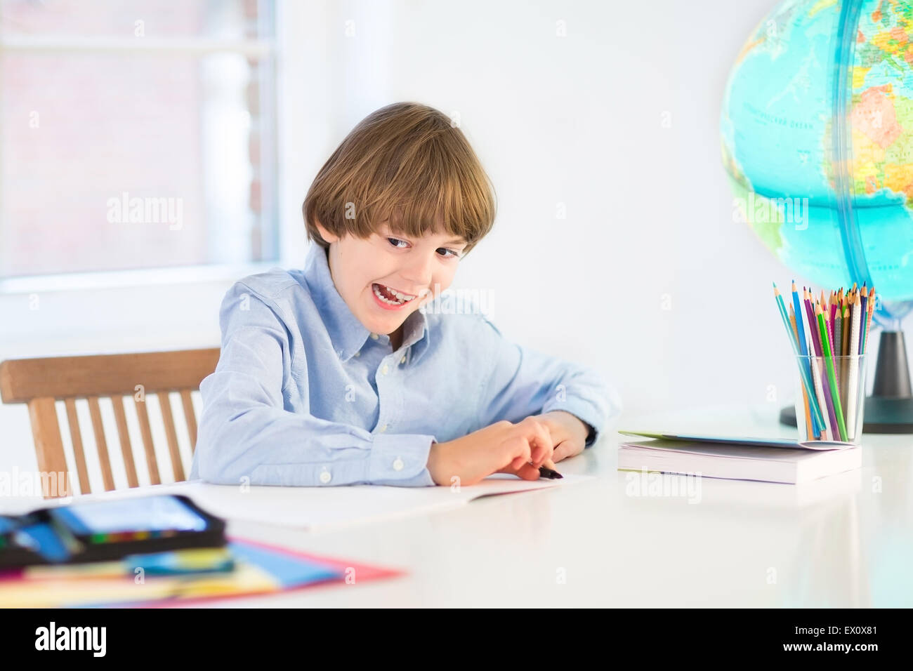 Portrait of a school boy doing his homework at home Stock Photo - Alamy