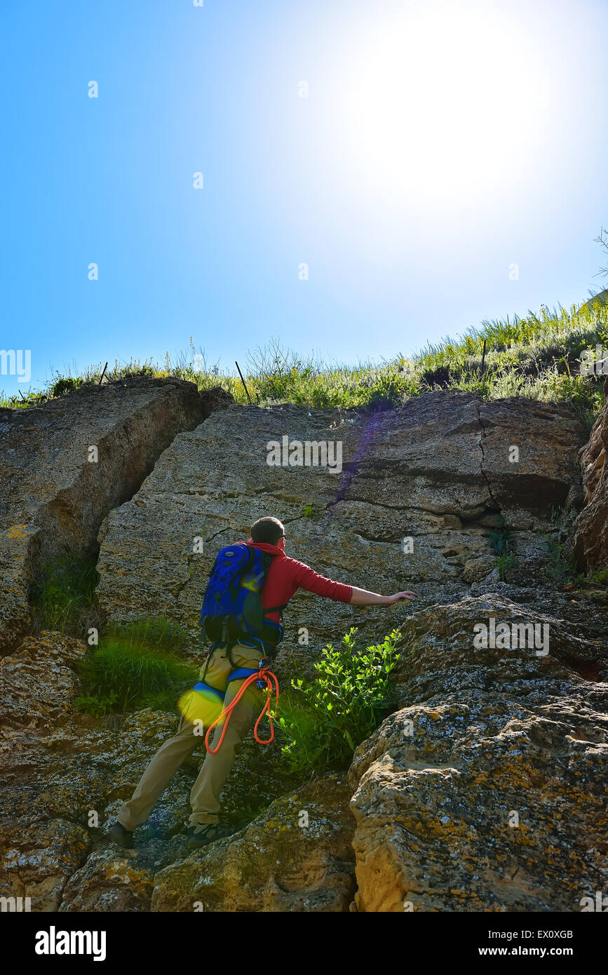 rock-climber with blue backpack climbing on rock Stock Photo - Alamy