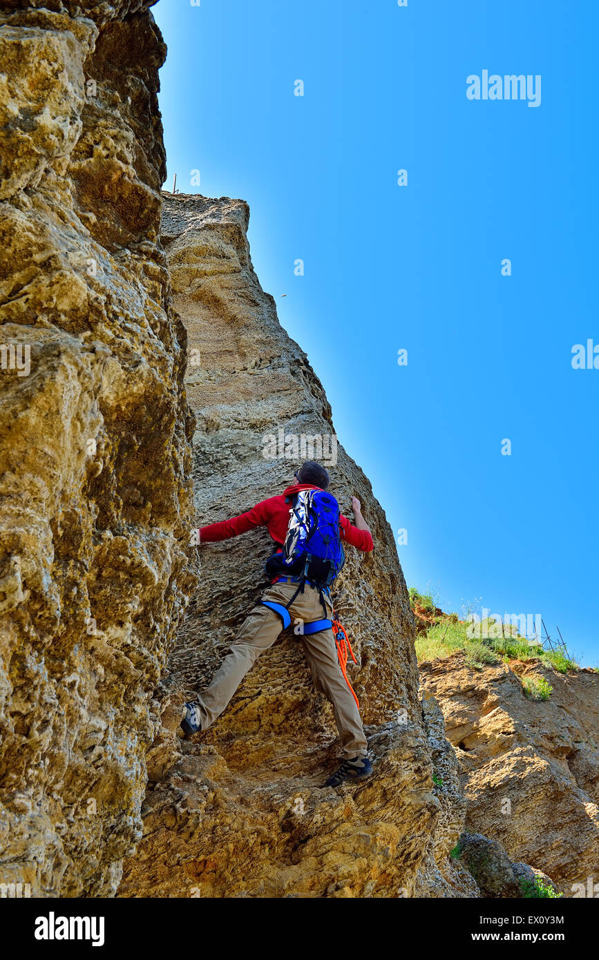 young rock climber climbing up a yellow cliff Stock Photo - Alamy
