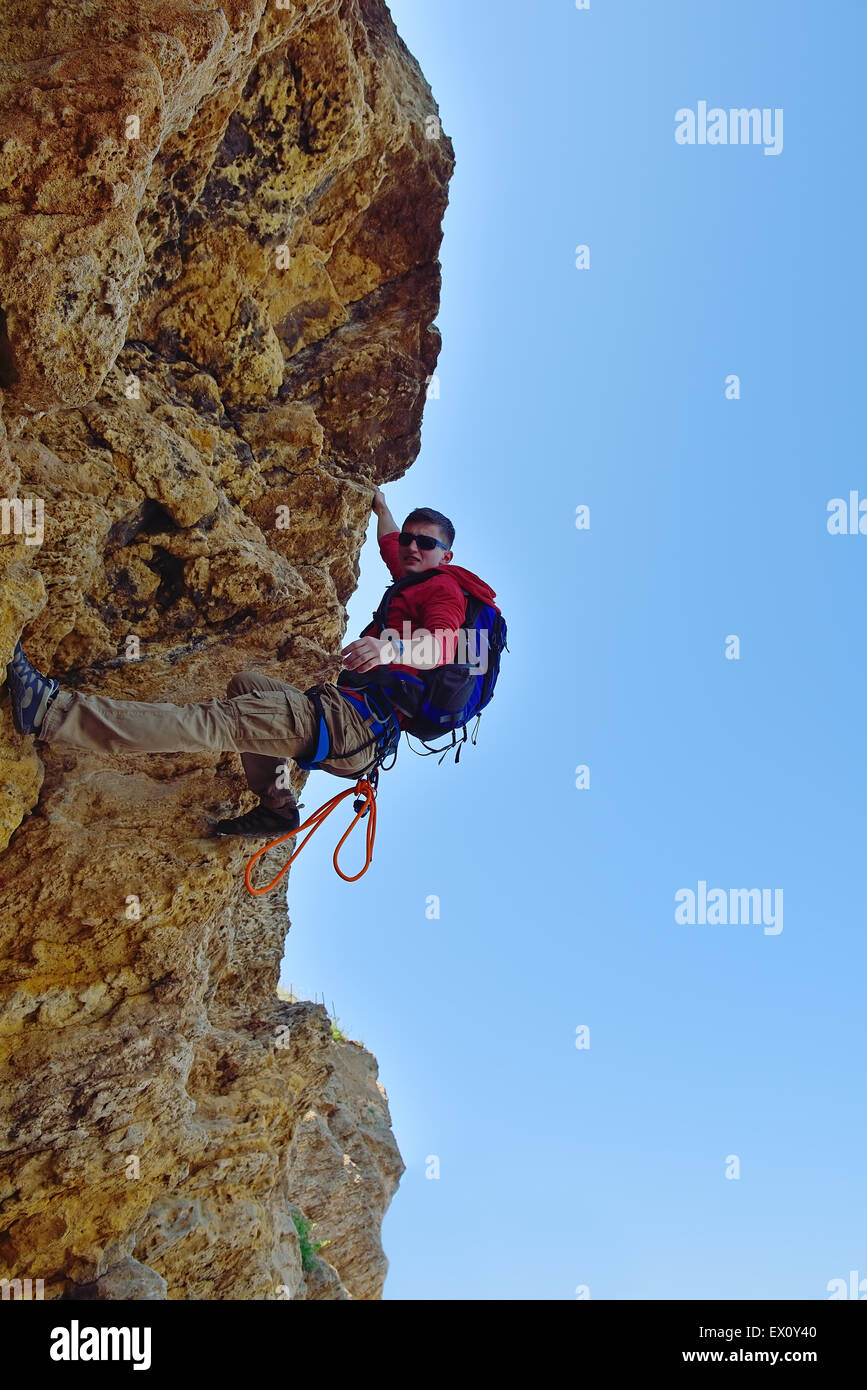 climber with backpack hanging on the rock Stock Photo - Alamy