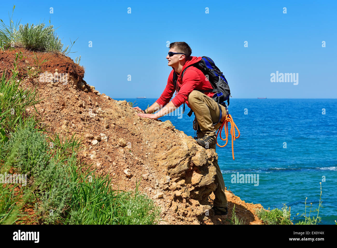 tourist with backpack climbing on top of mountain Stock Photo - Alamy