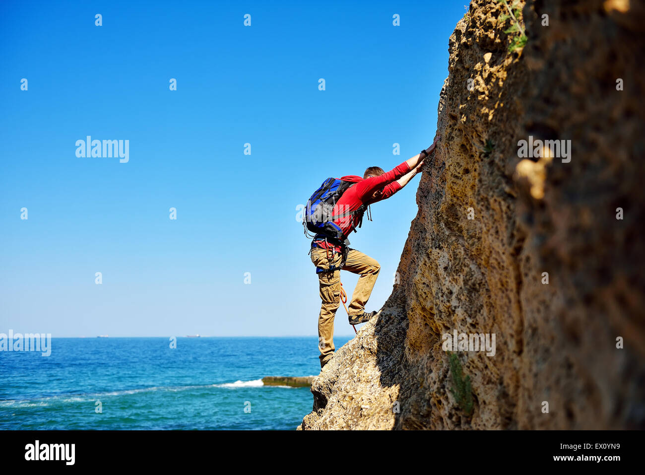 climber with backpack climbing on top of mountain Stock Photo - Alamy