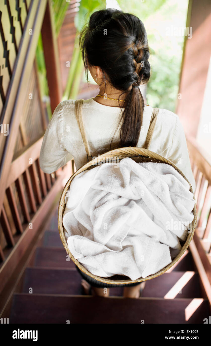 A chamber maid carries room towels in a basket on her back at 3 Nagas ...