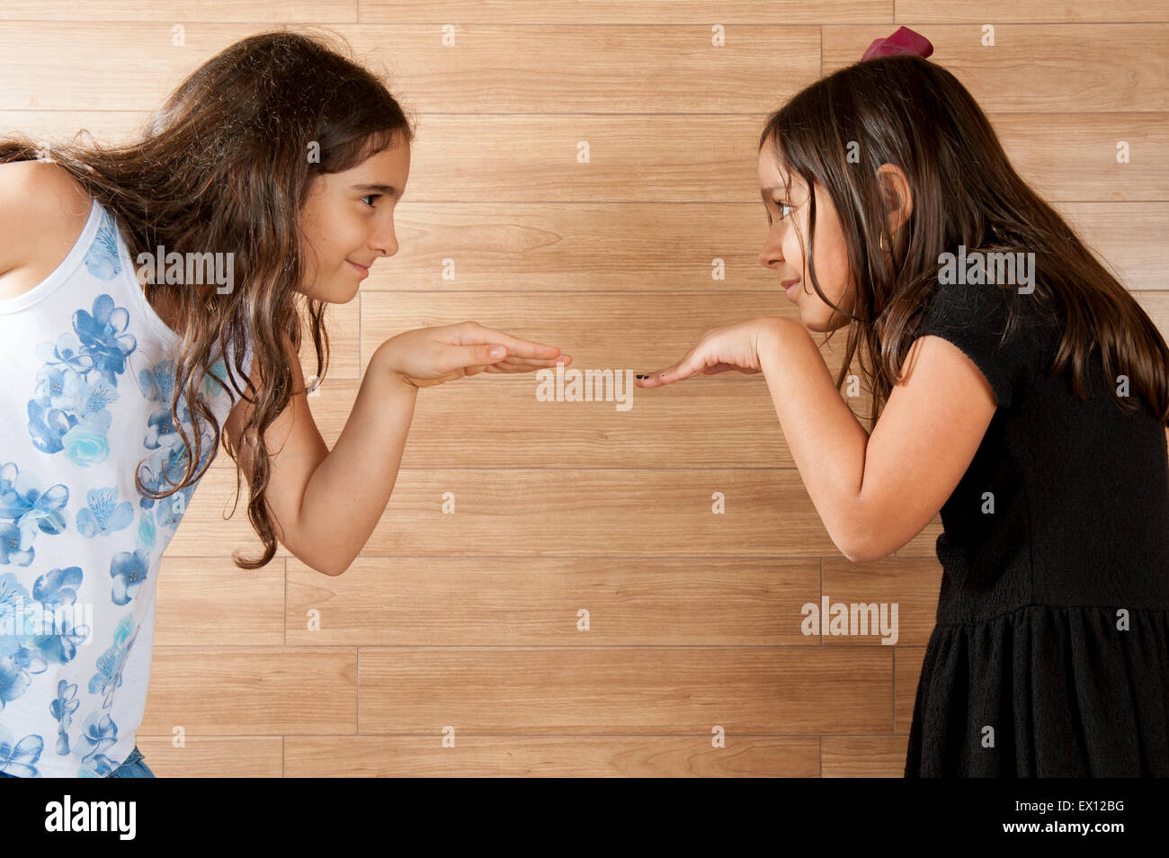 Two cute young girls playing indoor Stock Photo - Alamy