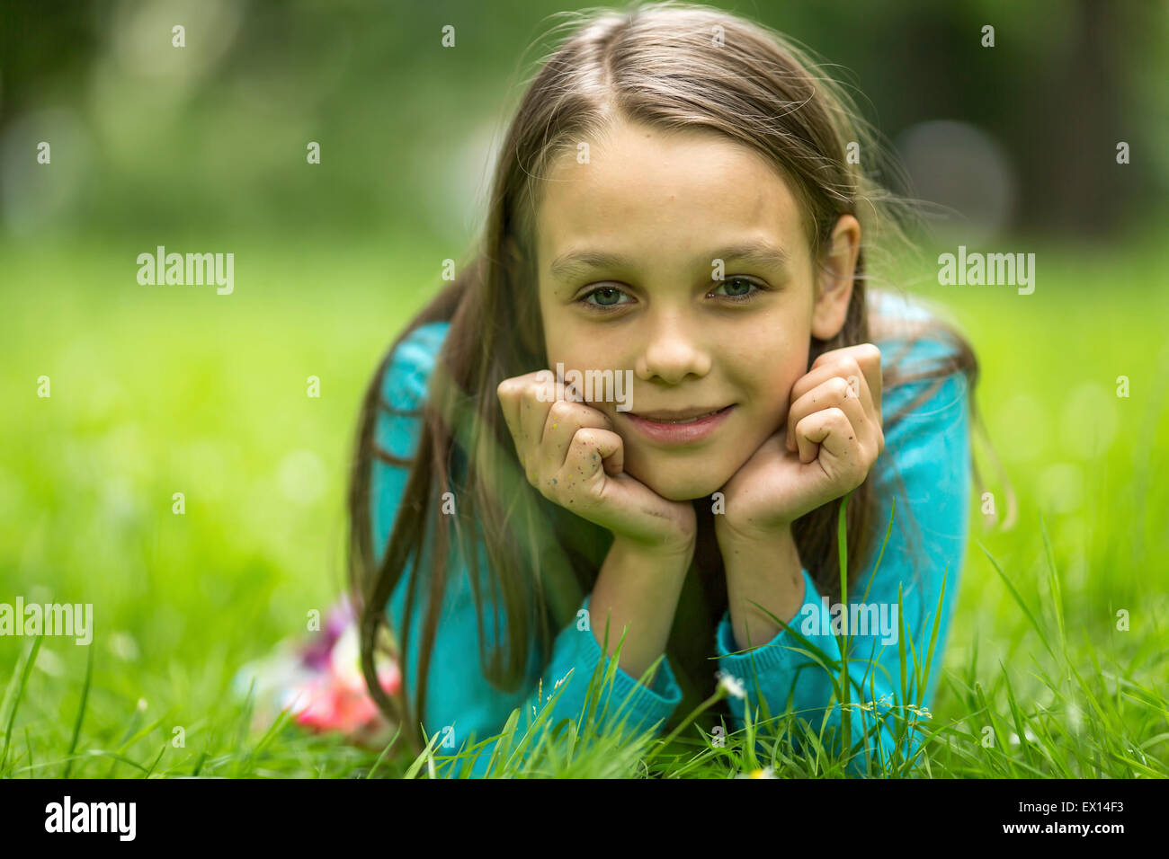 Close Up Portrait Of A Nine Year Old Girl Lying In The Green Grass