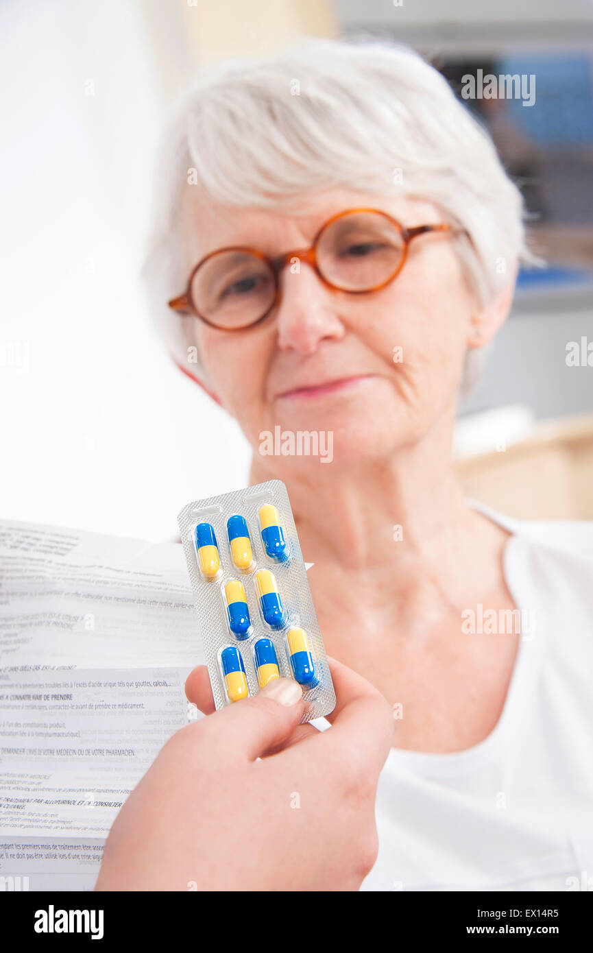 MODEL RELEASED. Person holding prescription medicine and leaflet with a ...