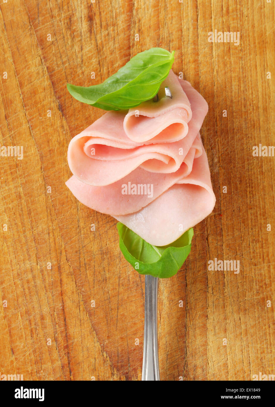 Thin slices of ham on fork Stock Photo - Alamy