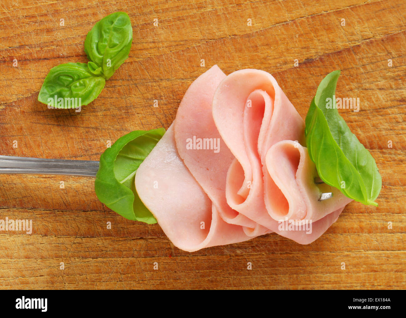 Thin slices of ham on fork Stock Photo - Alamy