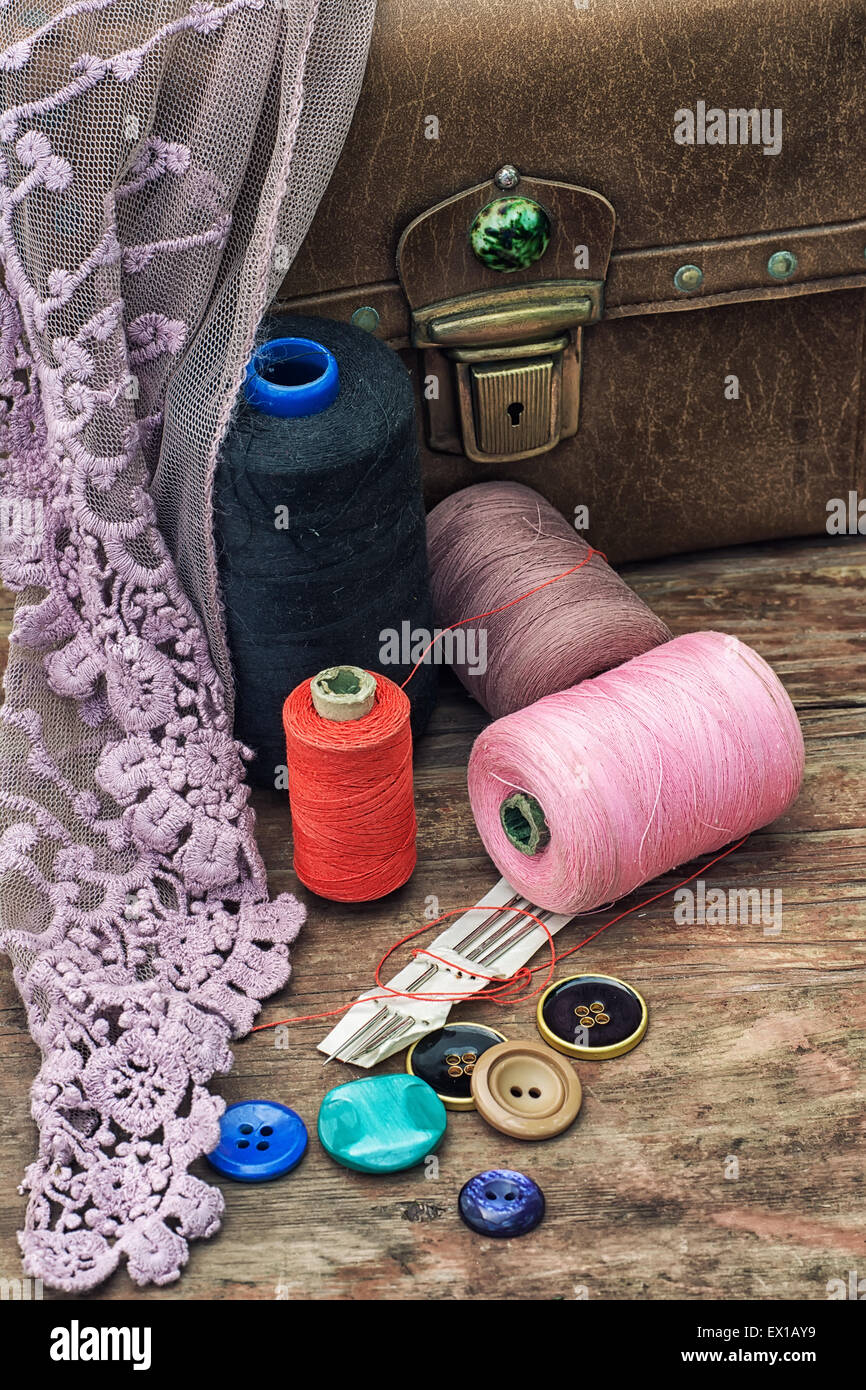 spools of thread on background of old vintage suitcase with draped ...
