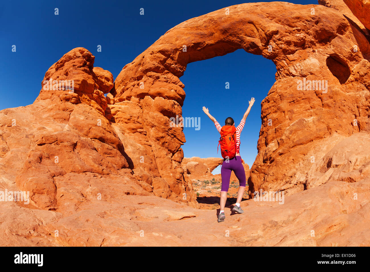 Woman with arms up walking to the arches Utah Stock Photo - Alamy