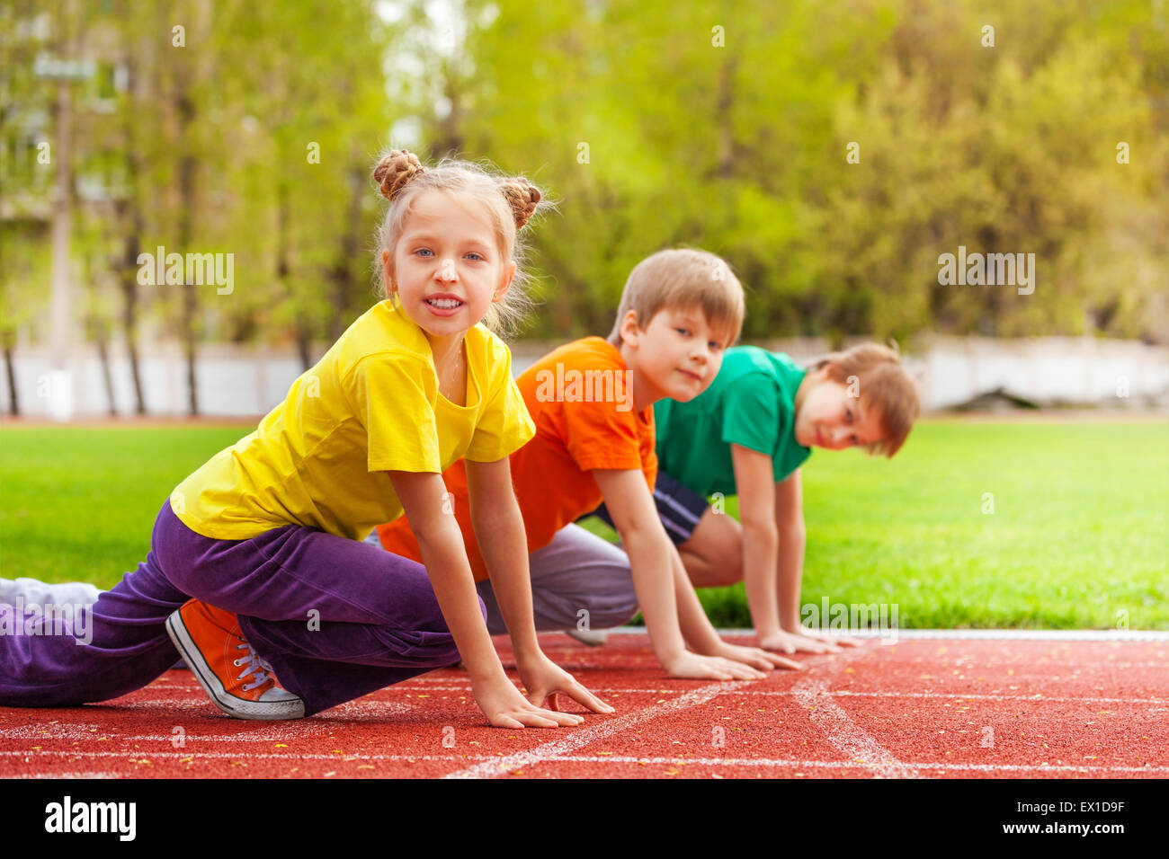 Children stand with bended knee ready to run Stock Photo - Alamy