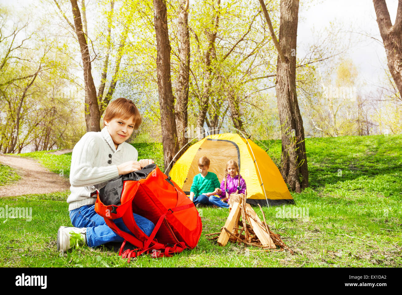 Boy packing the things into red rucksack in camp Stock Photo - Alamy