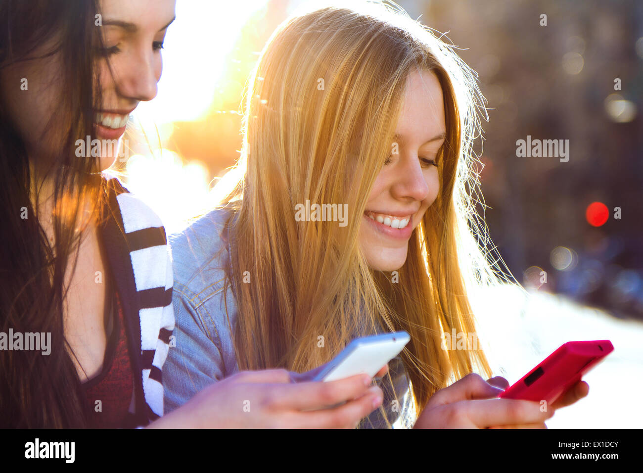 A group of friends chatting with their smartphones in the street Stock ...