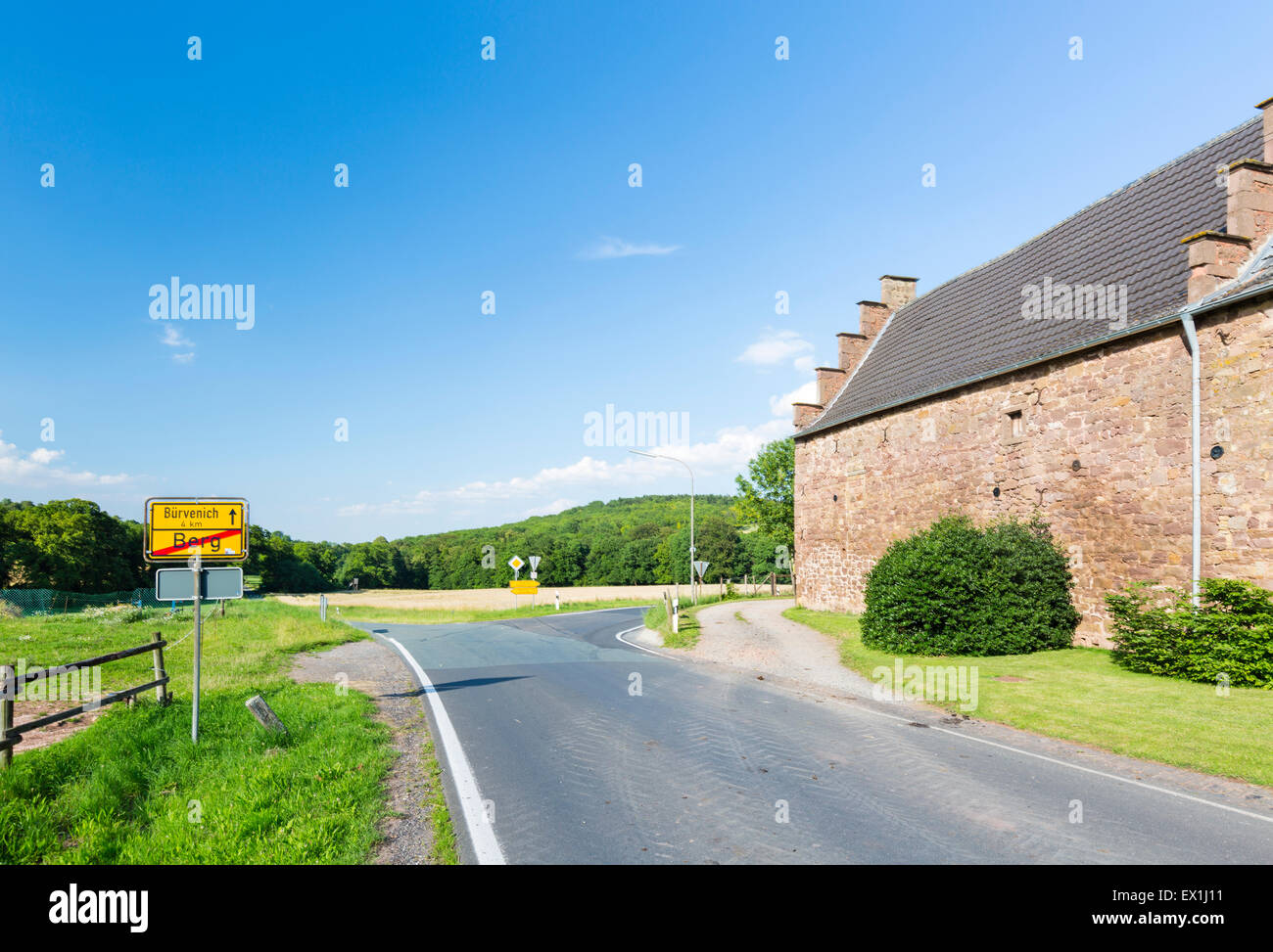 A country road leading past farm buildings fortified like a small ...