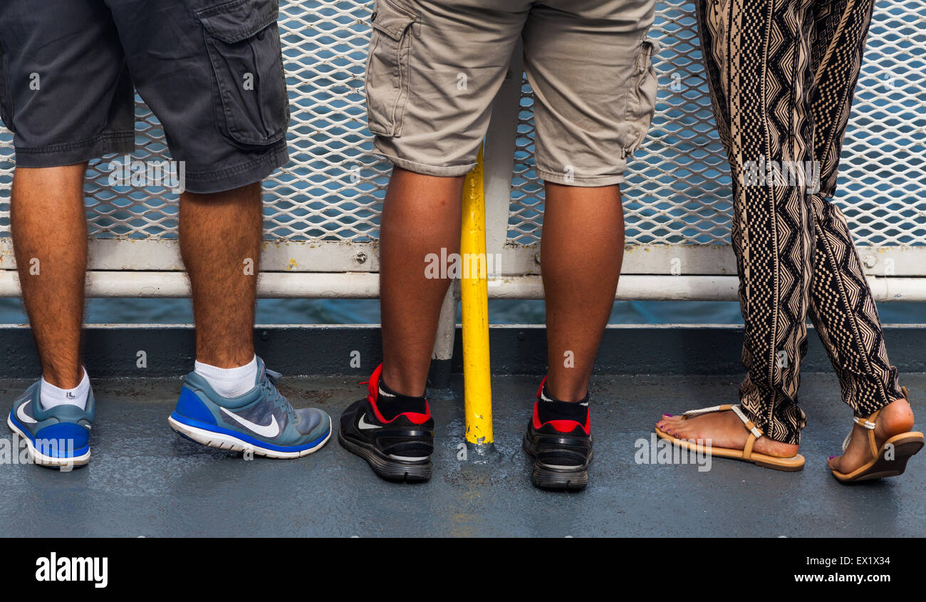 Legs and feet of three people on the deck of a ship Stock Photo - Alamy