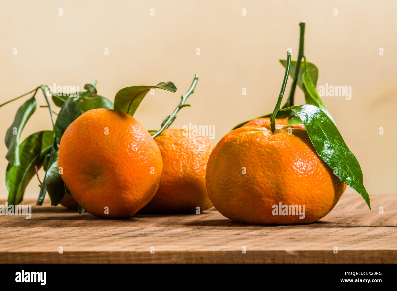 Ripe tangelos with green leaves on a wooden table Stock Photo - Alamy