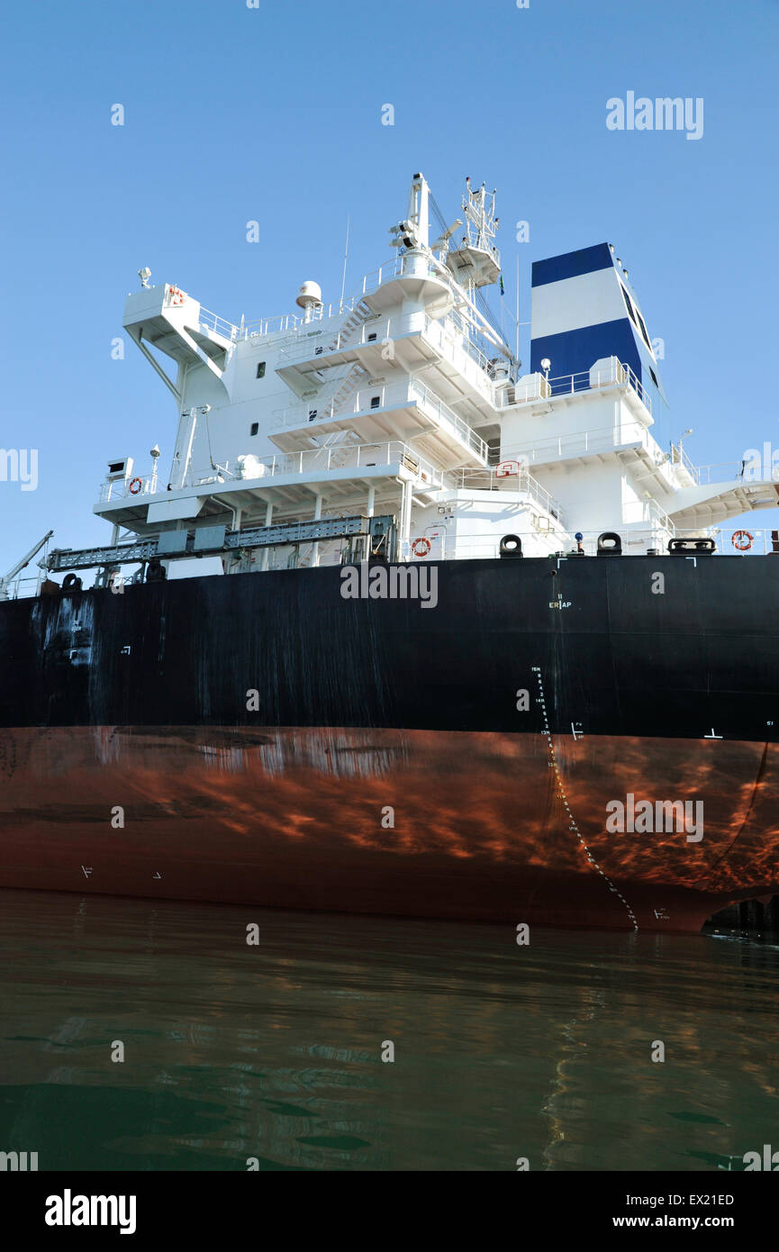 White superstructure of cargo ship with sunlight reflecting on hull of ...