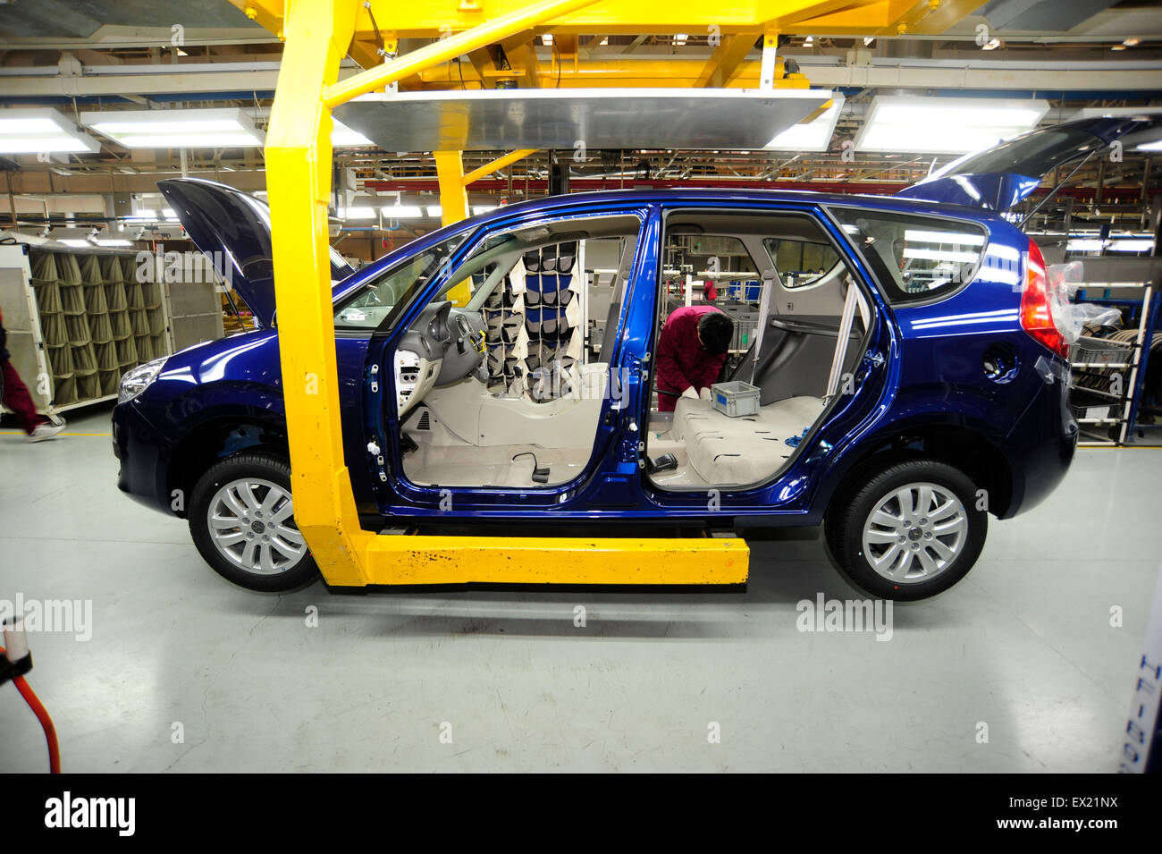 Employees install car doors along the assembly line of Anhui Jianghuai ...