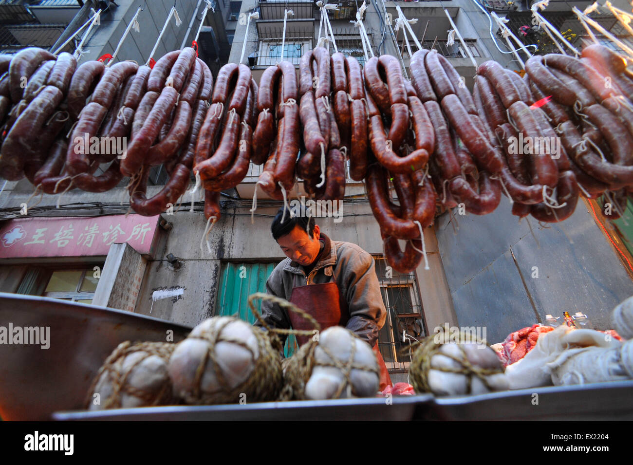 A meat product vendor waits for customers on street in Xiangfan, Hubei ...