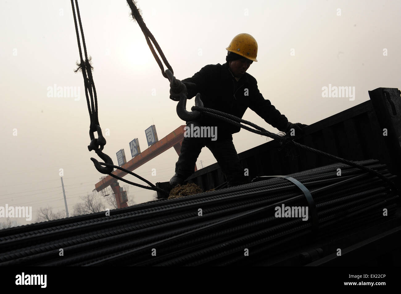 A labourer prepares for transporting bundles of steel bars at a steel ...