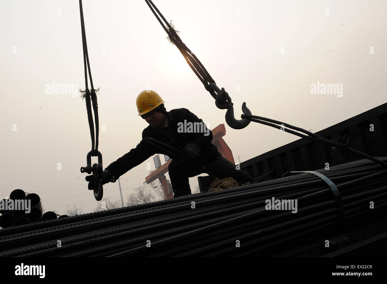 A labourer prepares for transporting bundles of steel bars at a steel ...