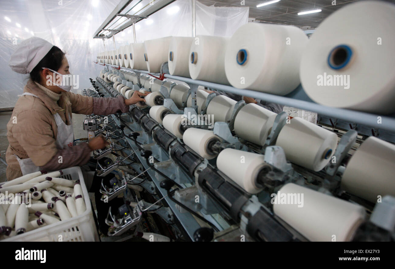 A female labourer works at a textile factory in Huaibei, Anhui province ...