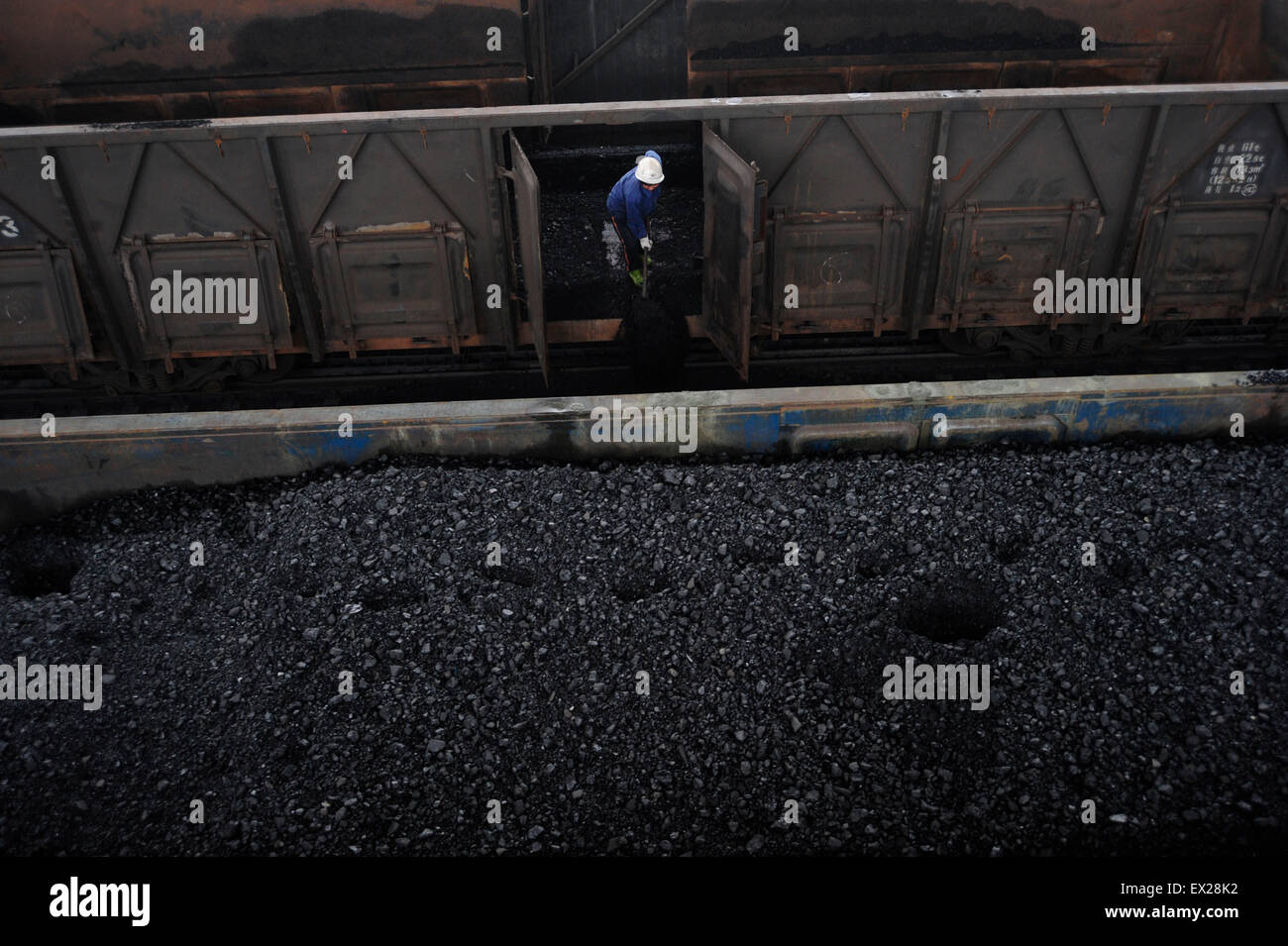 A labourer loads coal at a coal dump site of a railway station in Hefei ...
