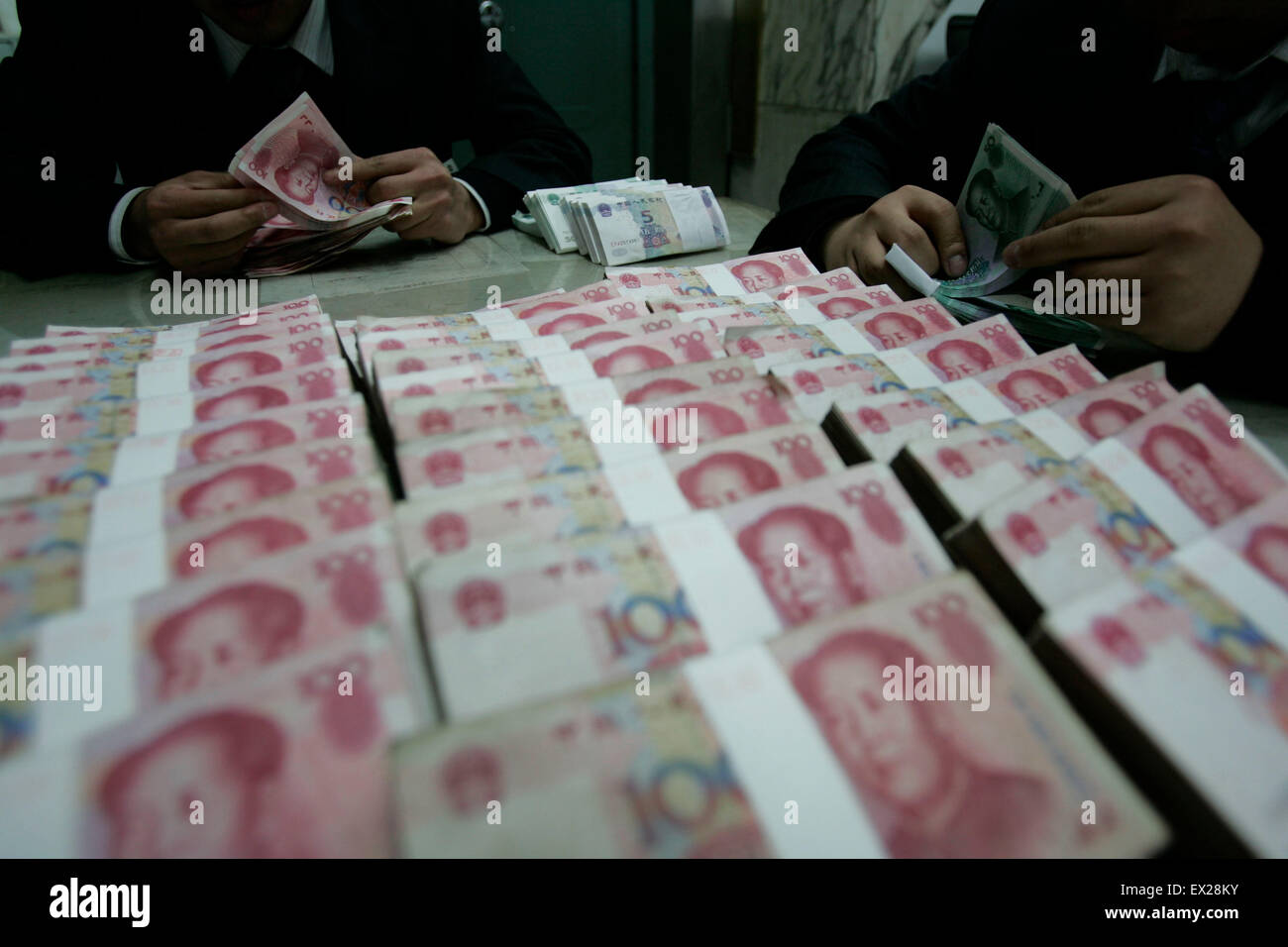 An employee counts Renminbi banknotes at a branch of Bank of China in ...