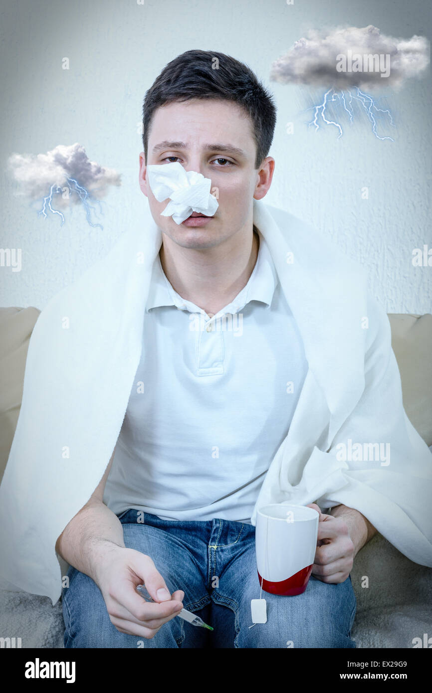 Man suffering from pollen allergy, dark storm clouds around his head ...