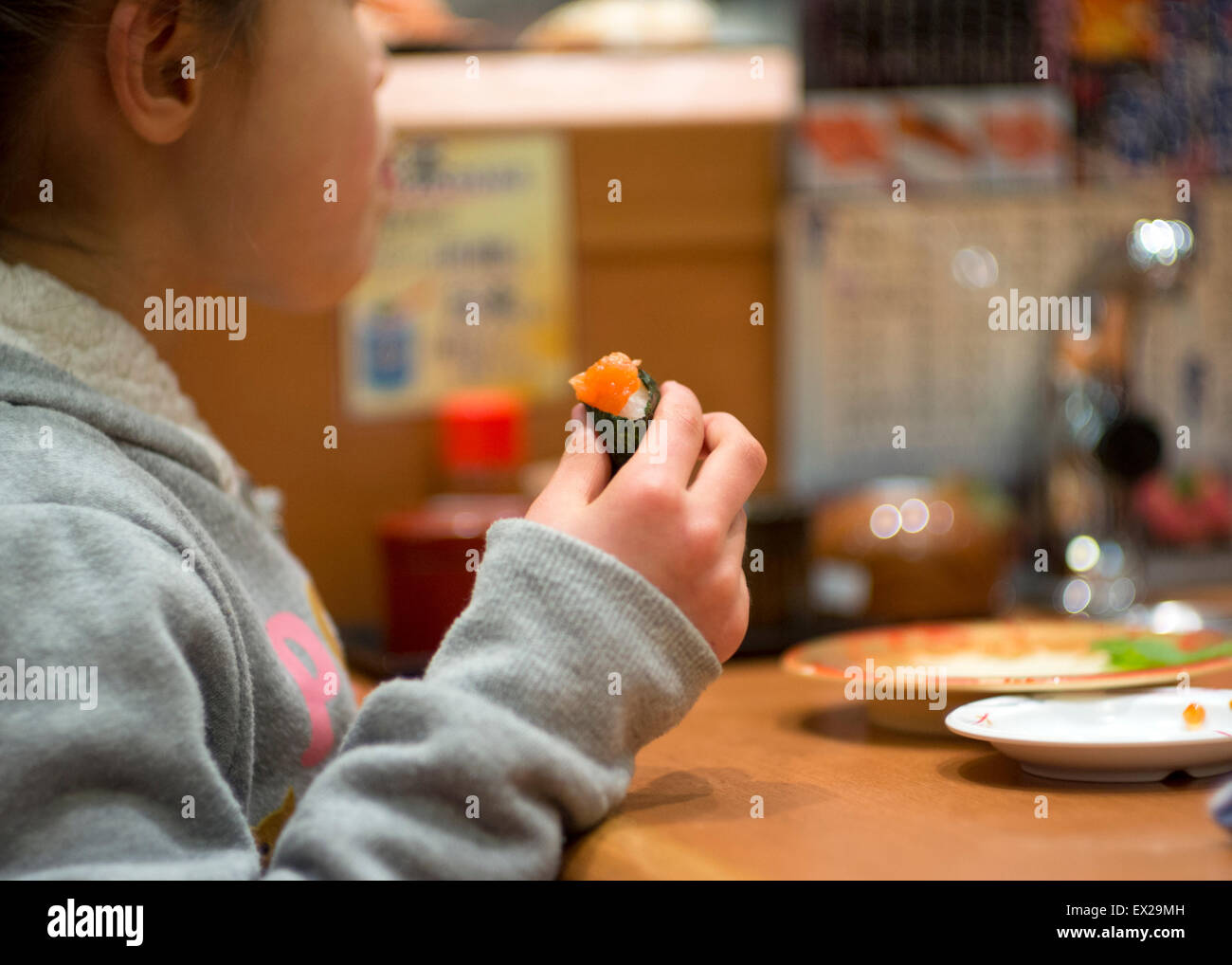 Child eating sushi at a restaurant Stock Photo - Alamy