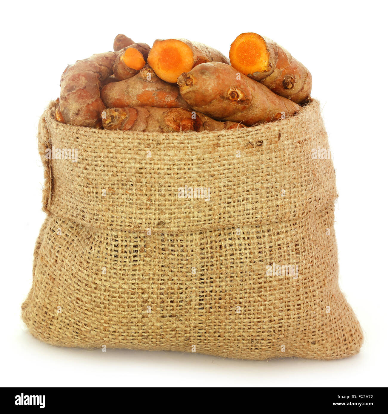 Turmeric in sack bag over white background Stock Photo - Alamy